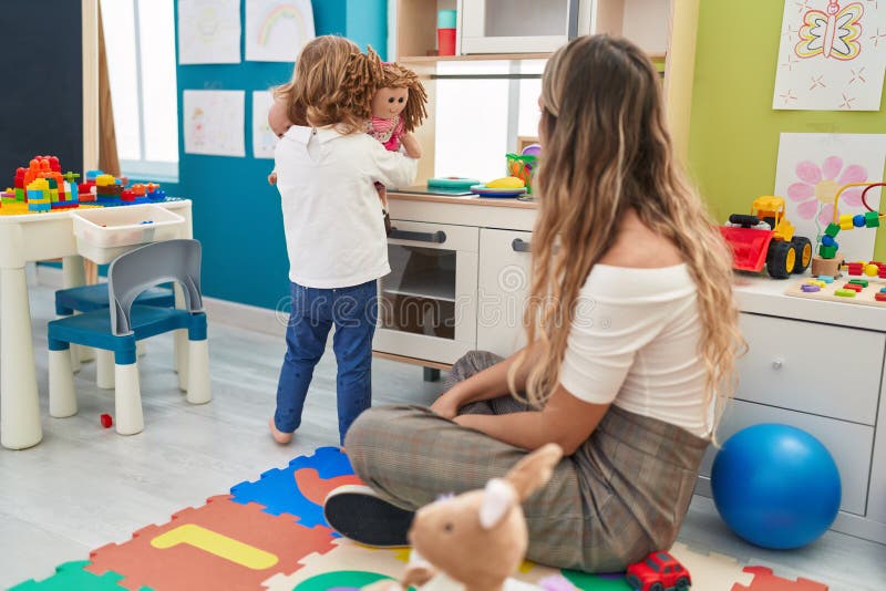 Teacher and Toddler Playing with Play Kitchen Standing at Kindergarten ...