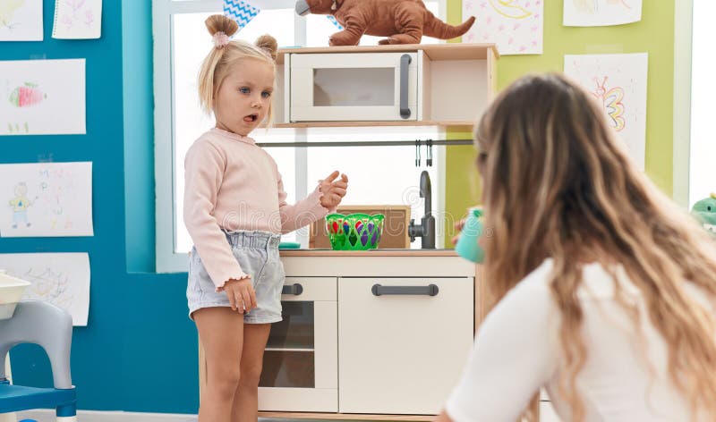 Teacher and Toddler Playing with Play Kitchen Standing at Kindergarten ...