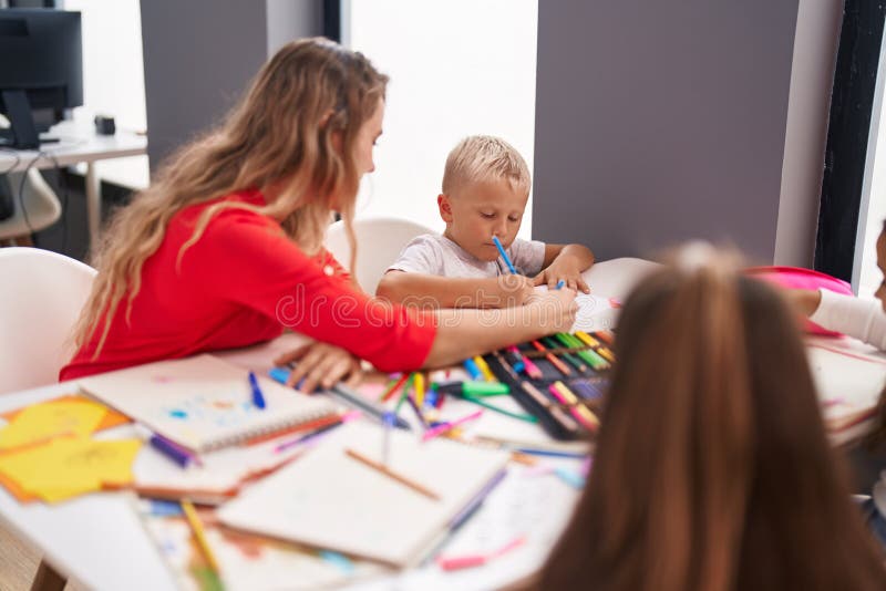Teacher and Toddler Sitting on Table Drawing on Paper at Classroom ...