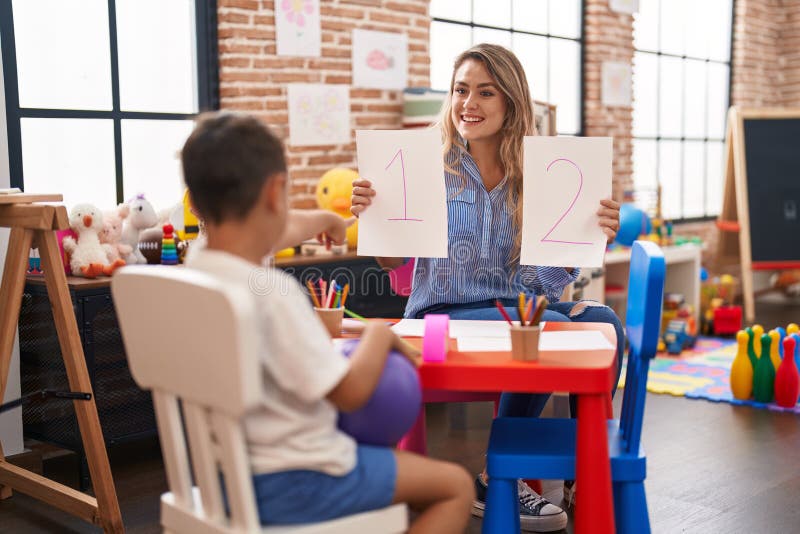 Teacher and Toddler Sitting on Table Having Maths Lesson at ...