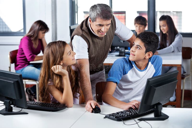 Teacher Using Computer with Students in Classroom Stock Photo - Image ...