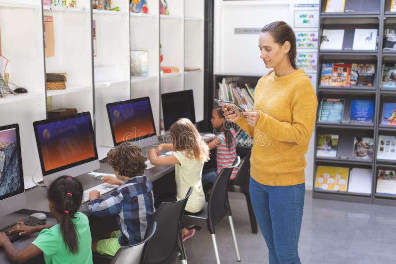 Teacher Using Digital Tablet in Computer Room Stock Photo - Image of ...