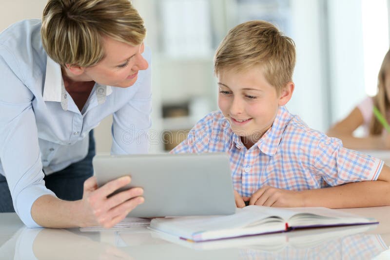 Teacher Using Digital Tablet with Pupil Stock Photo - Image of ...
