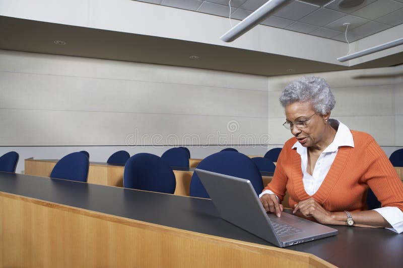Teacher Using Laptop in Classroom Stock Image - Image of female, black ...