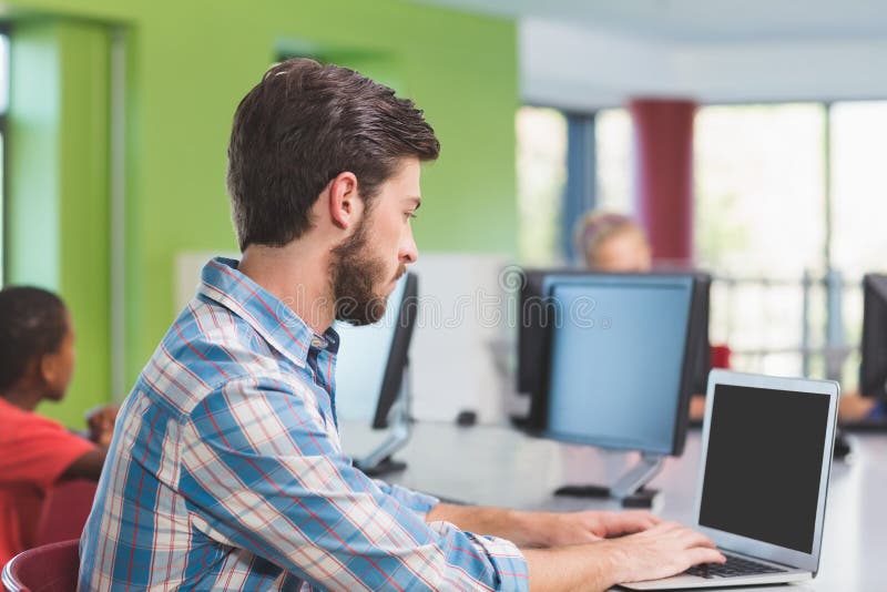 Teacher Using Laptop in Classroom Stock Photo - Image of casual, laptop ...