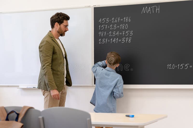 Teacher Working with Boy Pupil at Lesson Solving Math Tasks in ...