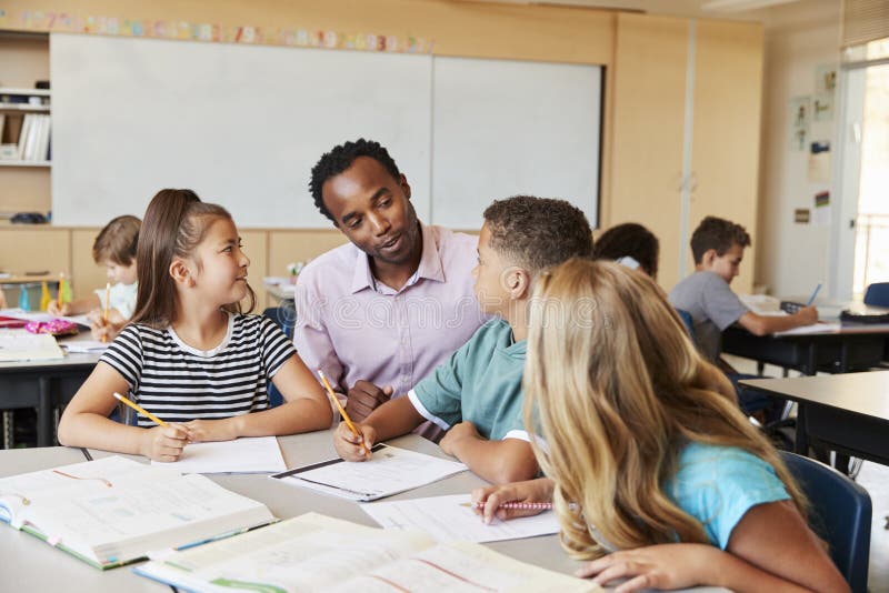 Teacher Working with Elementary School Kids at Their Desk Stock Image ...