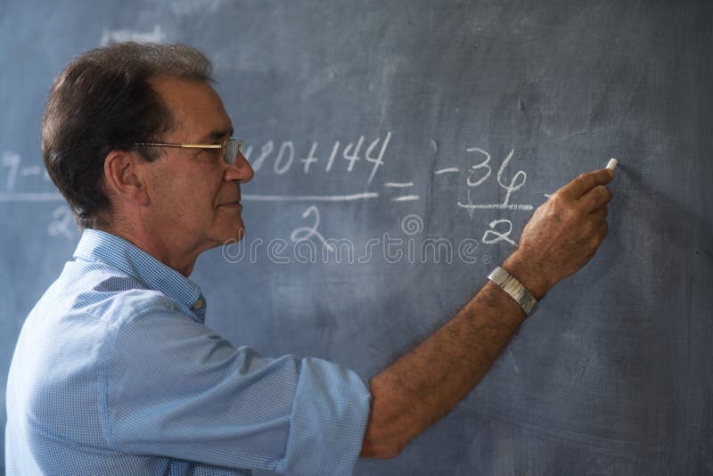 Teacher Writing Math Formulas on Blackboard at High School Stock Photo ...