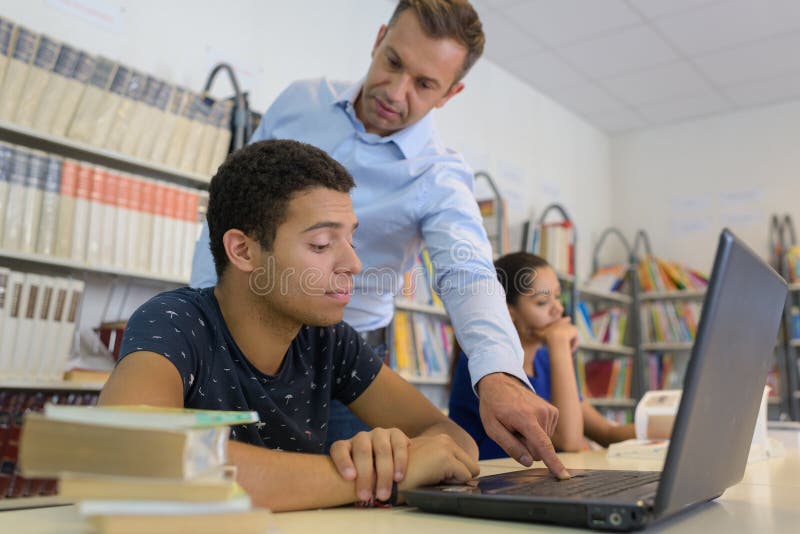 Teacher and Young Man with Laptop in Library Stock Image - Image of ...
