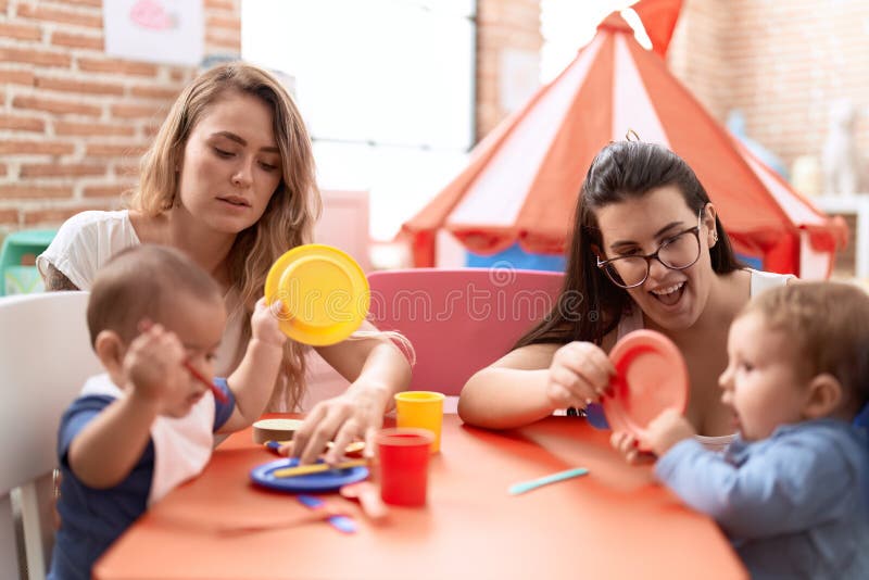 Teachers and Preschool Students Learning To Eat Sitting on Table at ...