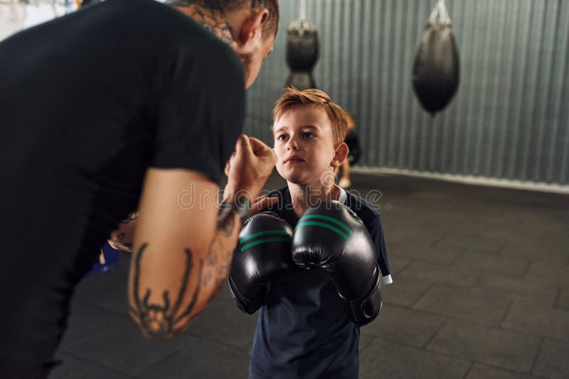 Teaching How To Punch. Coach is with Boy Showing Box Techniques Indoors ...