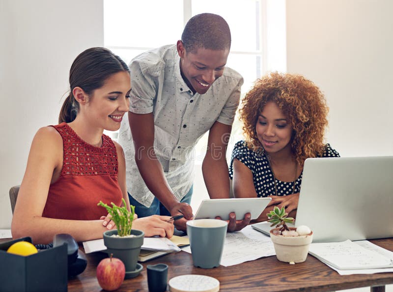 The Team in Action. a Group of Colleagues Working Together at a Desk in ...