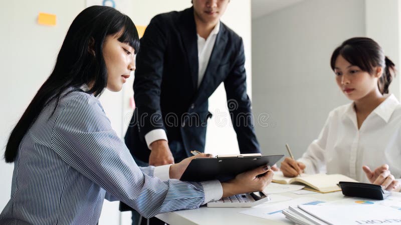 Team Analyzing Documents while Sitting on a Table in Office. Woman ...