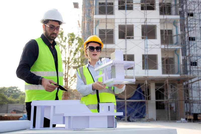 Team Architect and Builder Talking and Holding Model House at ...