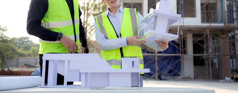 Team Architect and Builder Talking and Holding Model House at ...