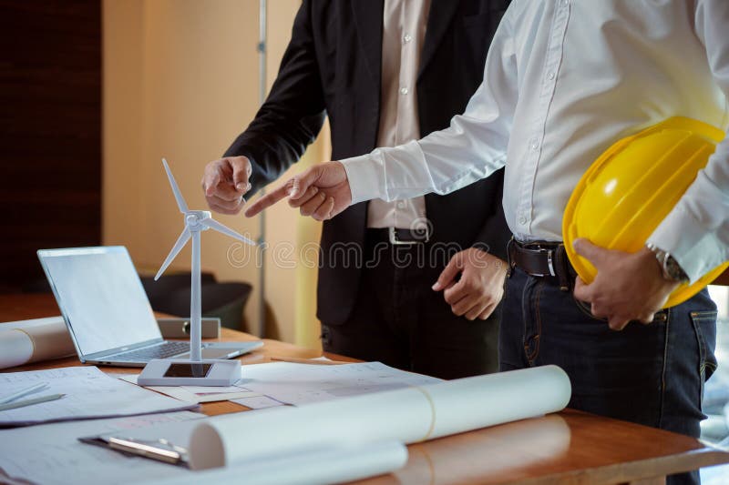 Team of Architect and Engineer Having a Discussion while Working with ...