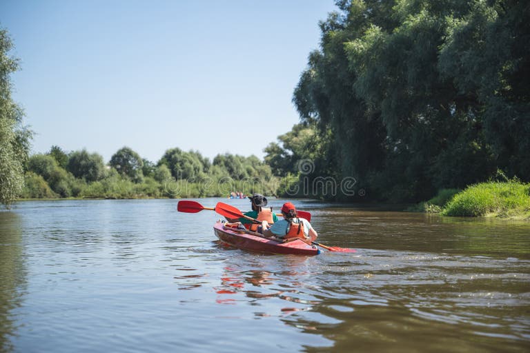 A Team of Athletes on a Canoe Overcomes Obstacles Floating on the River ...
