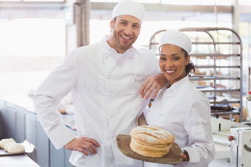 Team of Bakers Smiling at Camera with Loaf Stock Photo - Image of ...