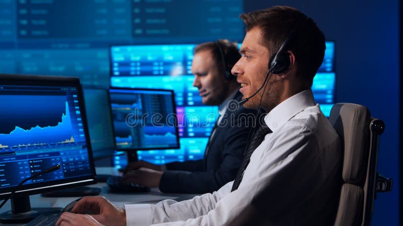 Team of Brokers is Working in Office Using Workstation and Analysis ...