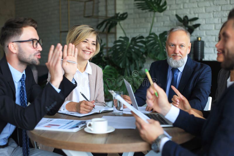 Team of Business People Having Discussion at Table in Creative Office ...
