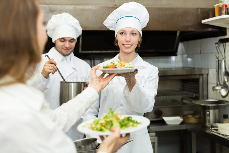 Smiling Waitress with Note Pad in Commercial Kitchen Stock Photo ...