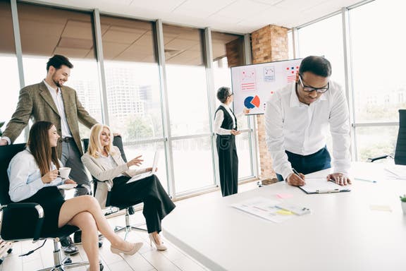 Team Collaborating in a Modern Office Working on a Project with Charts ...