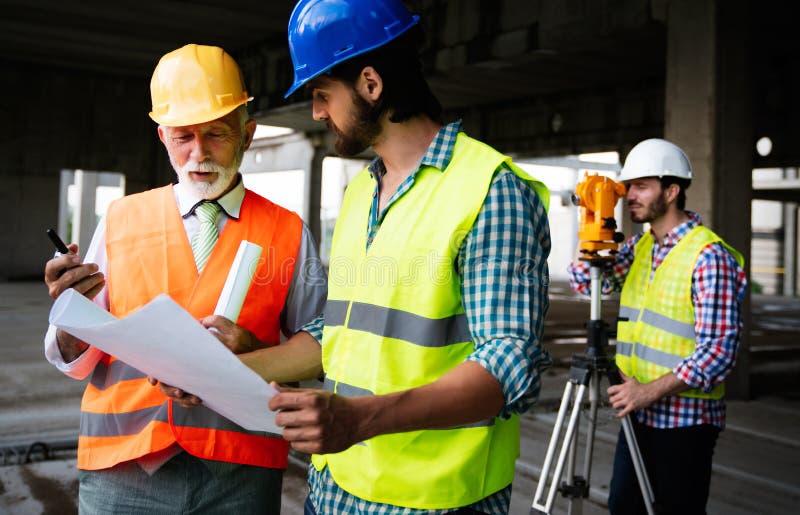 Team of Construction Engineers, Architects Working on Building Site ...