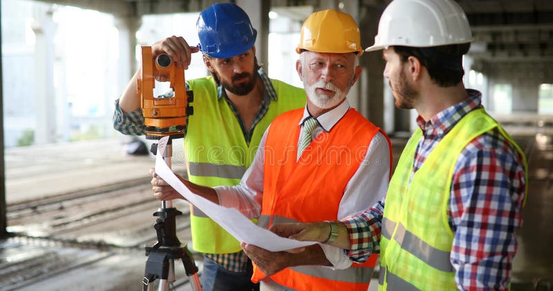 Team of Construction Engineers, Architects Working on Building Site ...