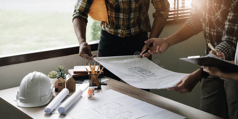 Team Construction Engineers Working at Construction Site with Blueprint ...