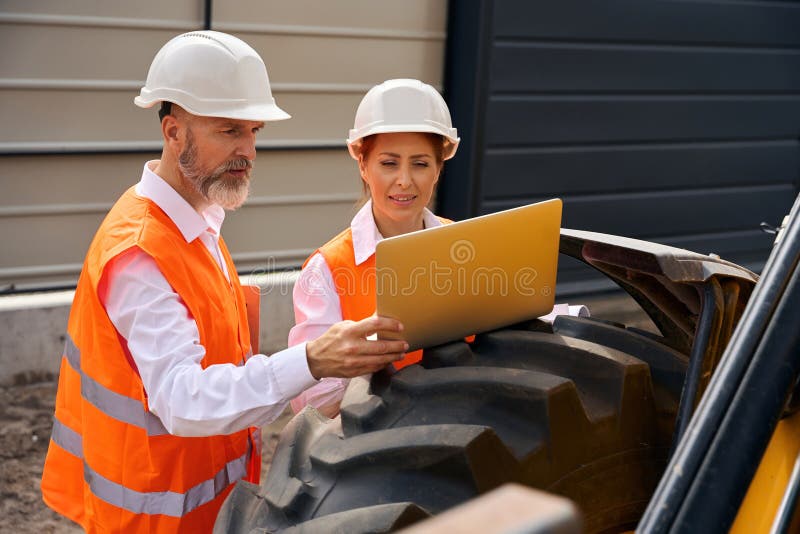 Team of Construction Specialists Using Together Computer during Site ...