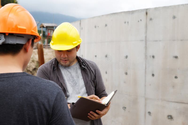 Team of Construction Workers Discussing Project Details with Blueprint ...