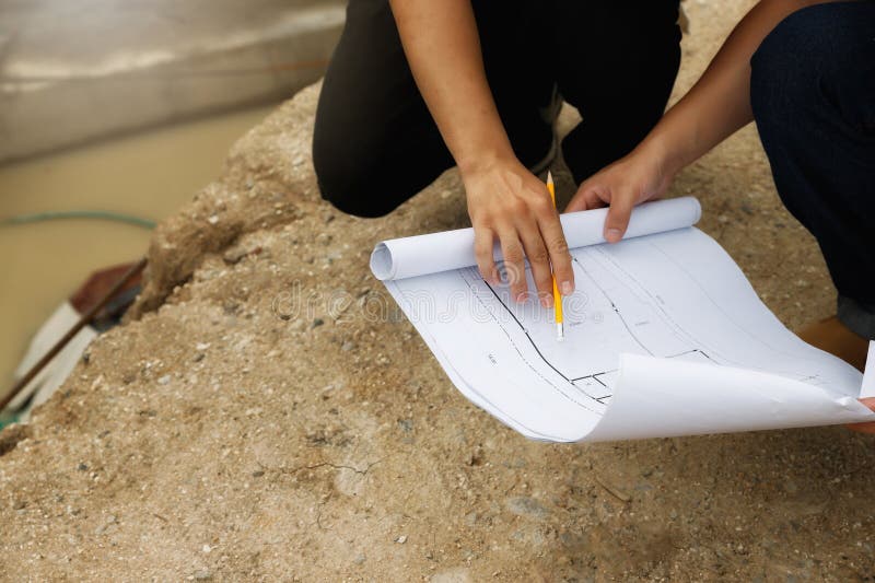 Team of Construction Workers Discussing Project Details with Blueprint ...