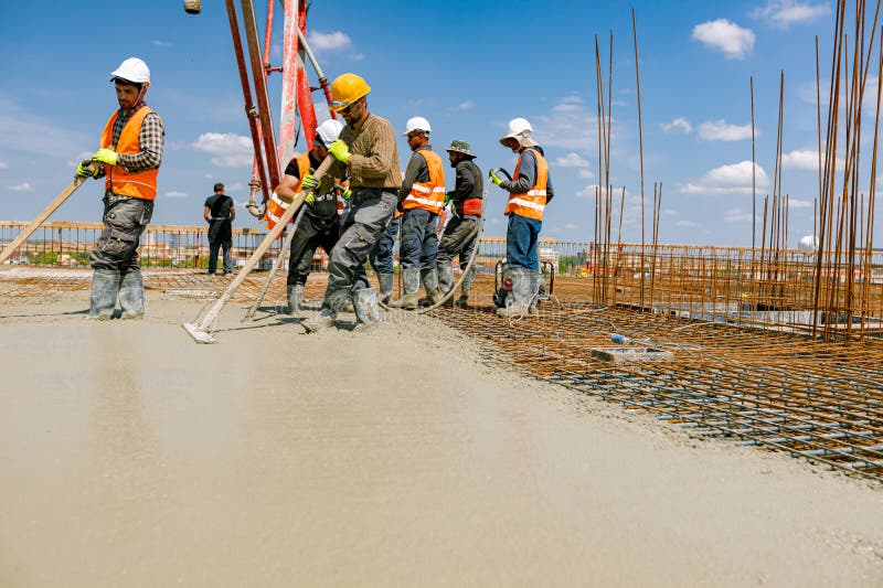 Workers in Rubber Boots are Pouring Fresh Concrete in Building ...