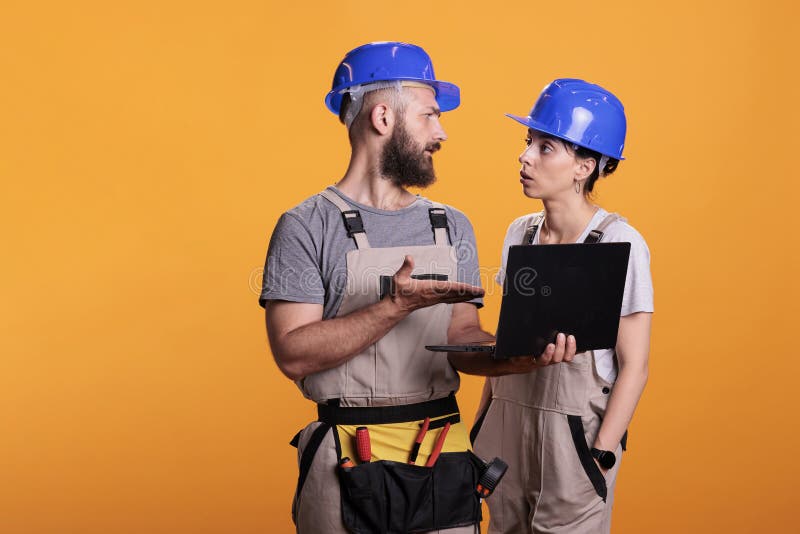 Team of Constructors Holding Laptop and Browsing Internet Stock Image ...