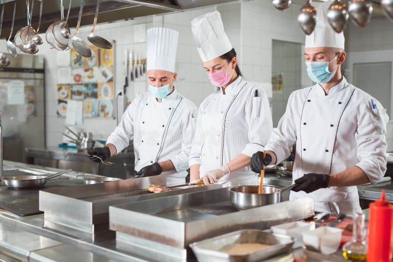 Team of Cooks Cooks in a Restaurant Stock Photo - Image of mask ...