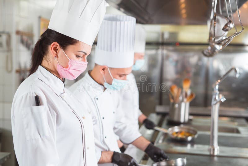 Team of Cooks Cooks in a Restaurant Stock Photo - Image of masks ...