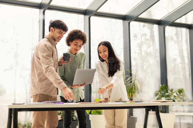 Team of Coworkers Using Laptop Engaging in Teamwork in Office Stock ...