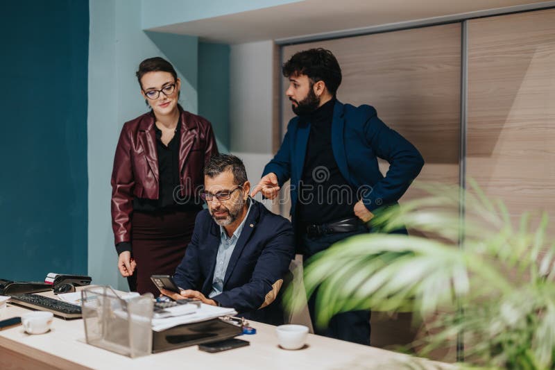 Team Discussing Strategy Around a Desk in a Modern Office Setting Stock Image - Image of ...