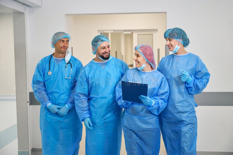 Team of Doctor and Nurses Communicating Standing in Corridor in Private ...