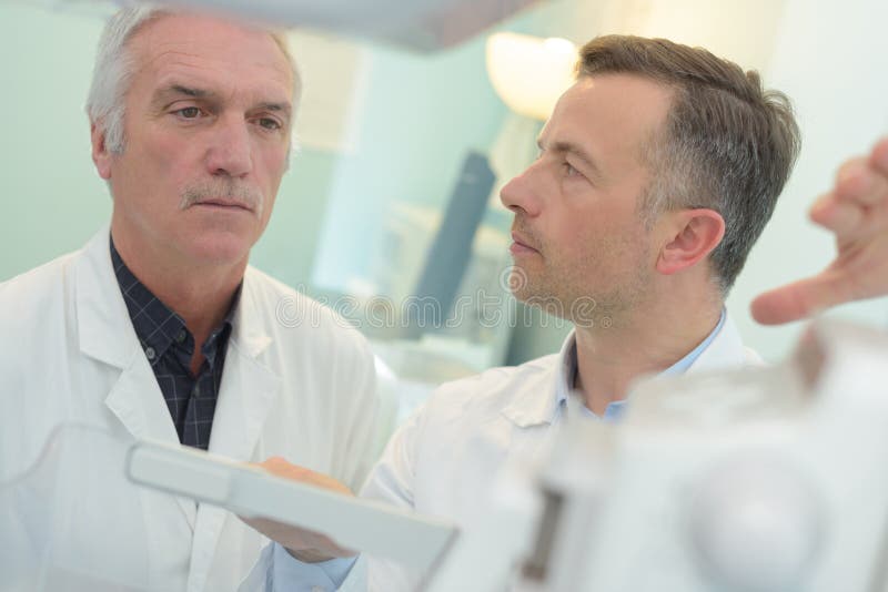 Team of doctors discuss stock image. Image of examining - 123019393