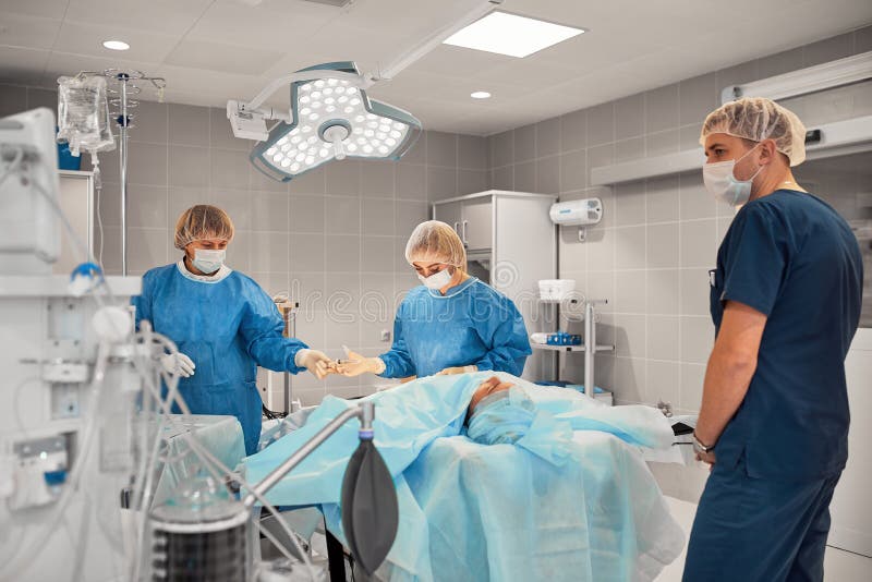 A Team of Doctors Performs an Operation. a Group of Surgeons at Work in ...