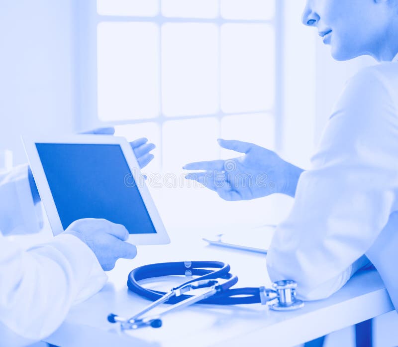 Team of Doctors Sitting at Table in Clinic Stock Photo - Image of ...