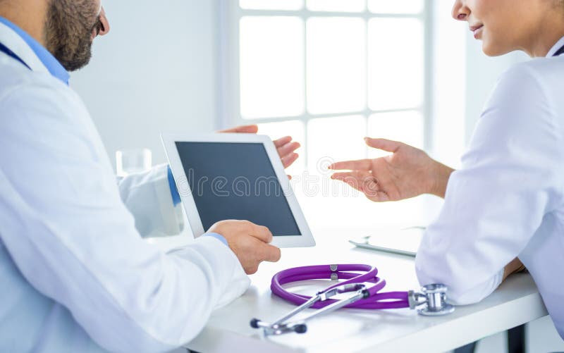 Team of Doctors Sitting at Table in Clinic Stock Photo - Image of ...