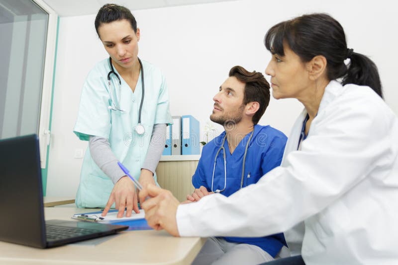 Team Doctors Sitting at Table in Row and Writing Stock Photo - Image of ...