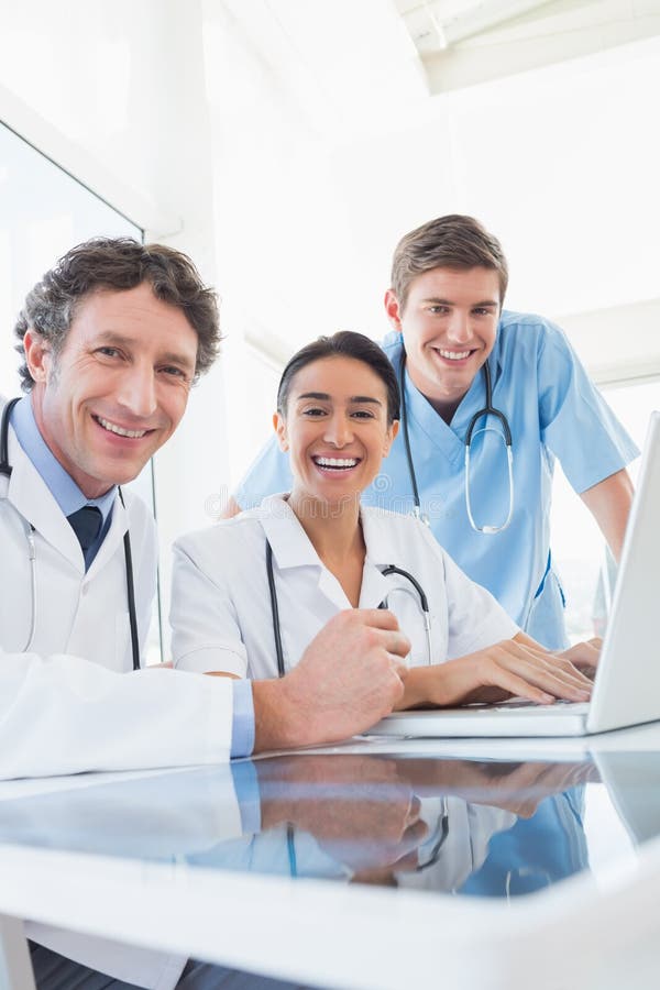 Team of Doctors Smiling at Camera Stock Photo - Image of coat, notebook ...
