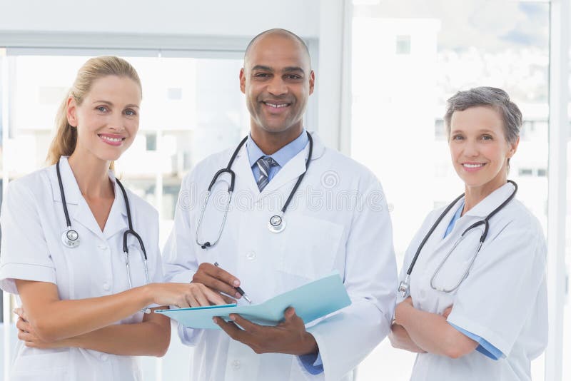 Team of Doctors Working Together on Patients File Stock Image - Image ...