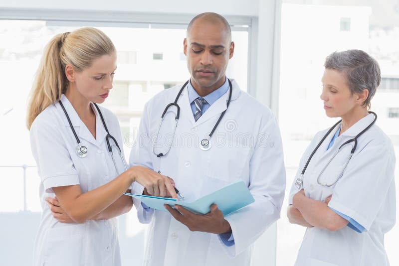 Team of Doctors Working Together on Patients File Stock Image - Image ...