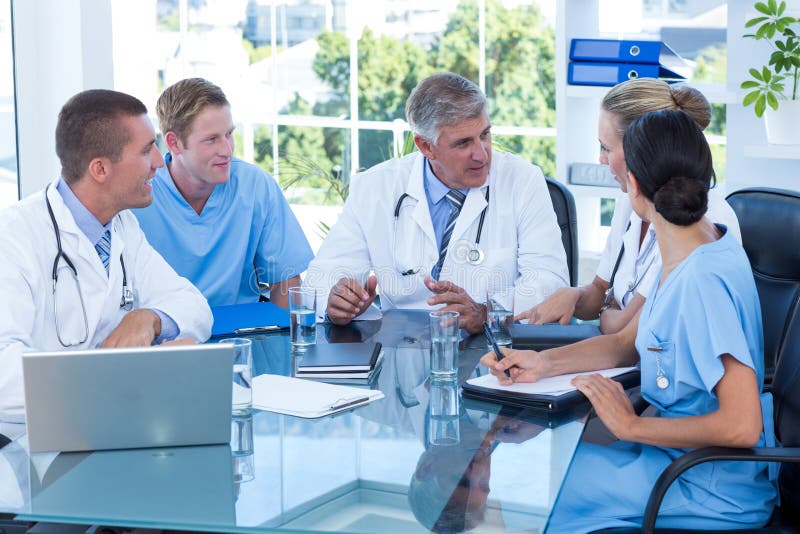 Team of Doctors Working Together on Patients File Stock Image - Image ...
