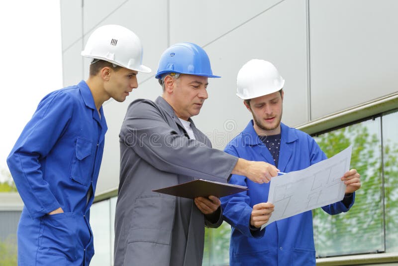 A Team of Electricians are Talking Near the Electrical Panel. a Man and ...