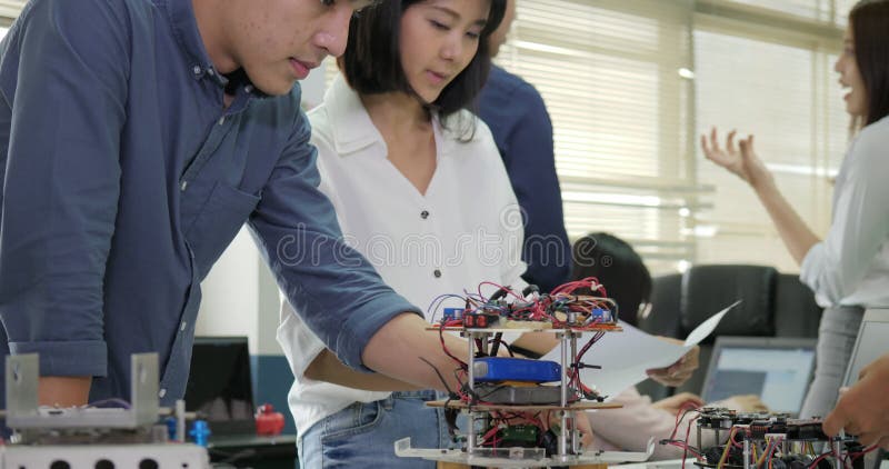 Team of Electronics Engineer Working Together, Collaborating on a ...